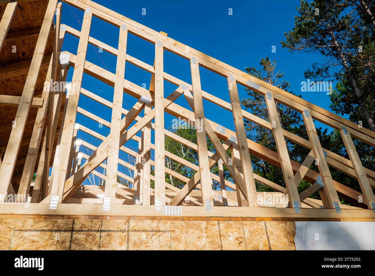 Wood rafters at a new home construction building site on a sunny day ...