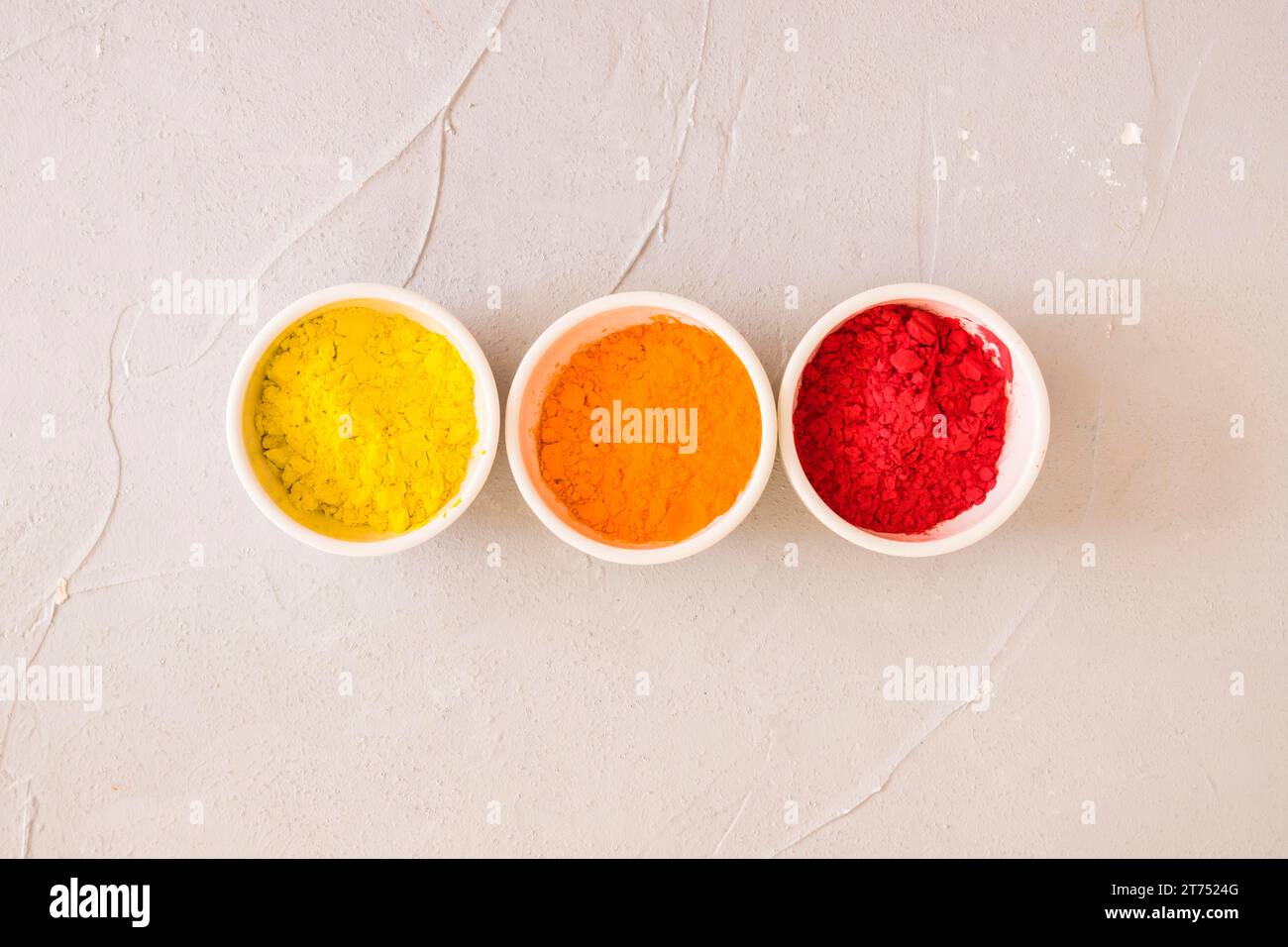 Elevated view white bowls with holi color powder simple background ...