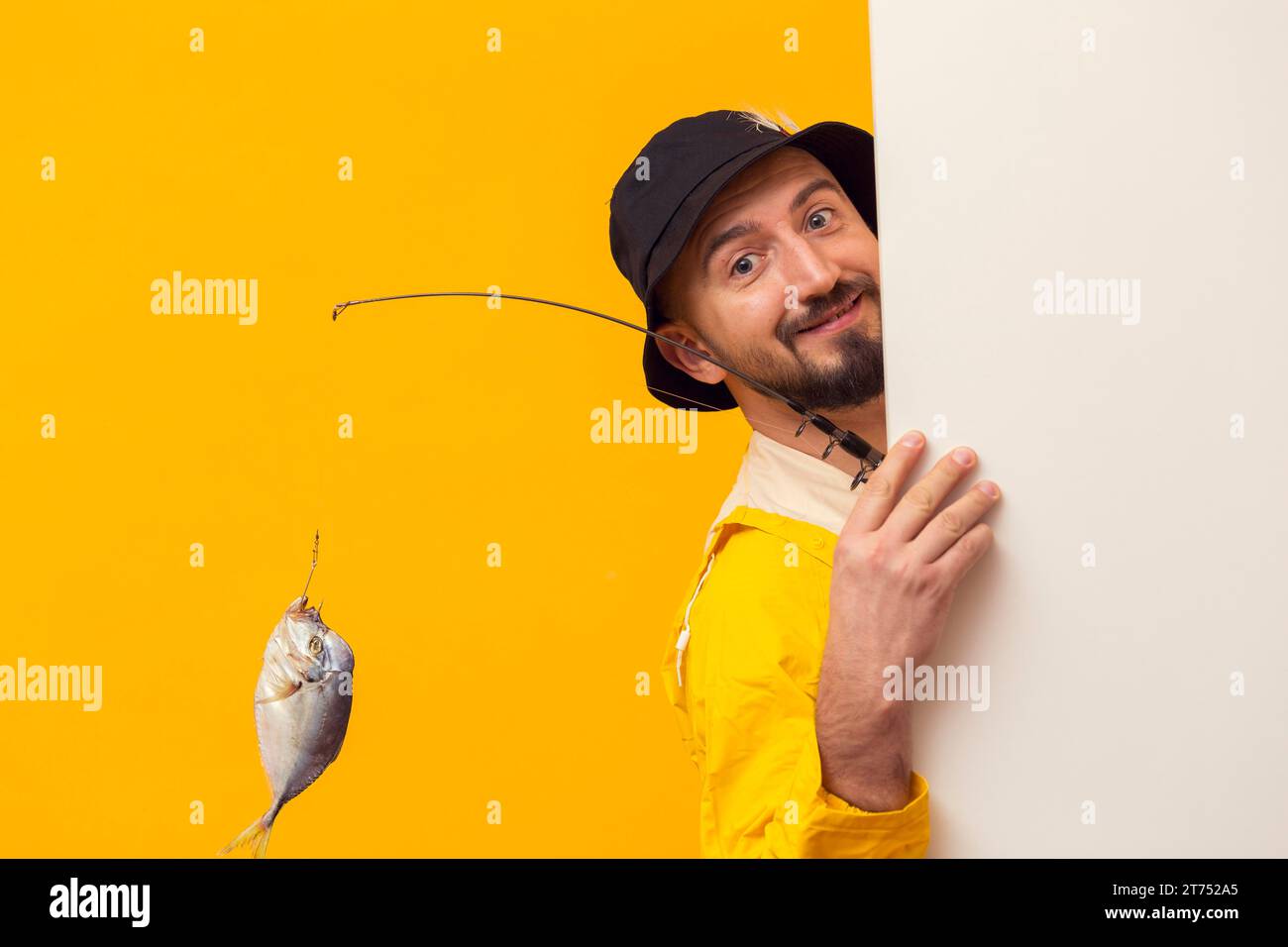 Fisherman holding fishing rod posing while smiling Stock Photo - Alamy