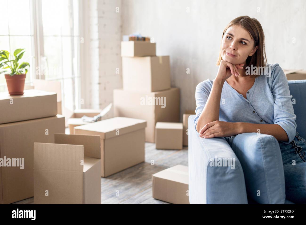 Front view pensive woman couch ready move out Stock Photo - Alamy