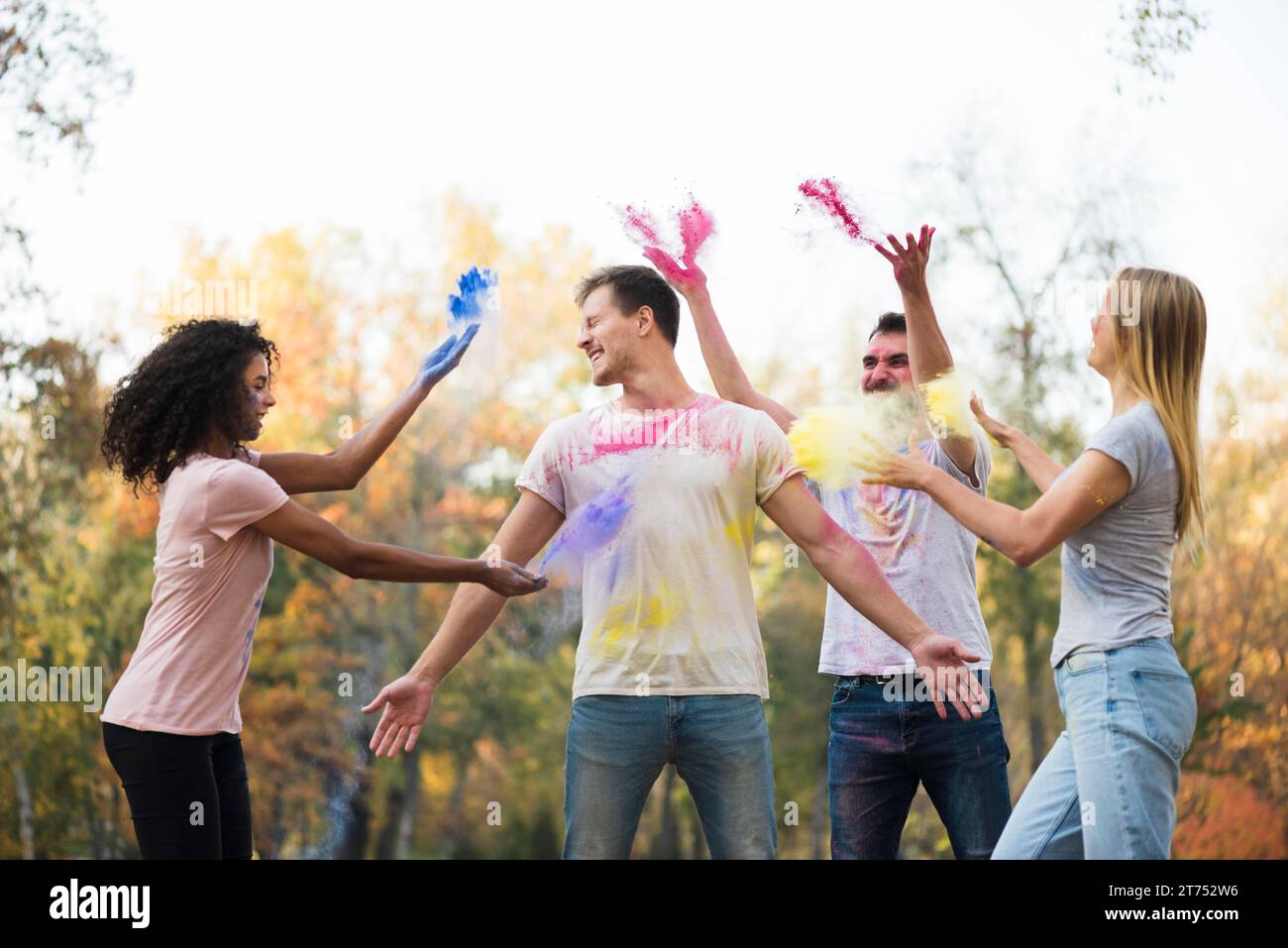 Group friends throwing powdered color air Stock Photo - Alamy