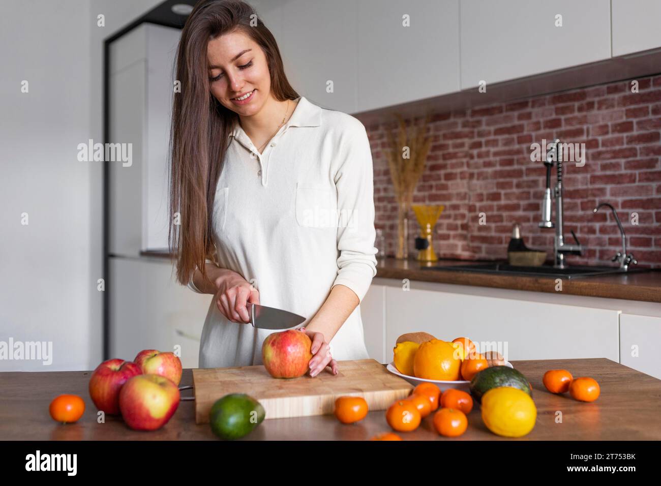 Medium shot woman cutting fruit Stock Photo - Alamy
