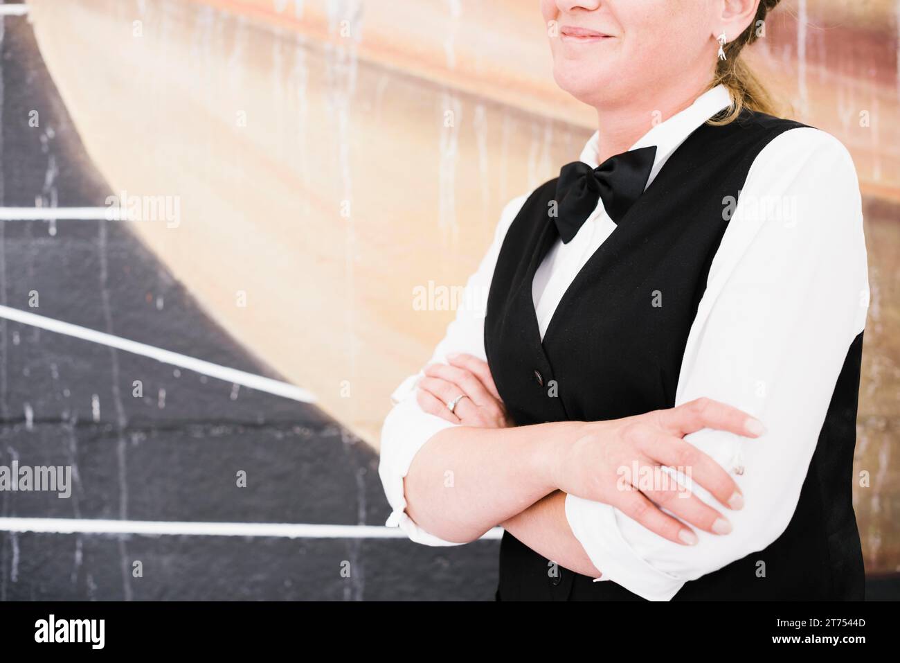 Smiley waiter holding hands waiting serve Stock Photo - Alamy