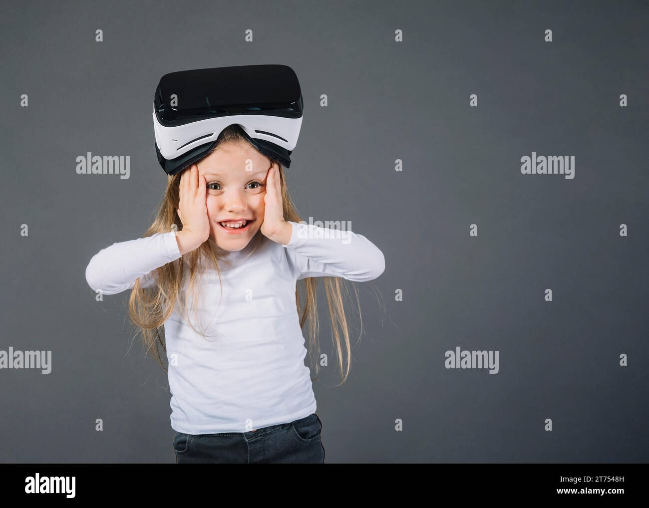 Surprised girl wearing virtual reality glasses her head touching her ...