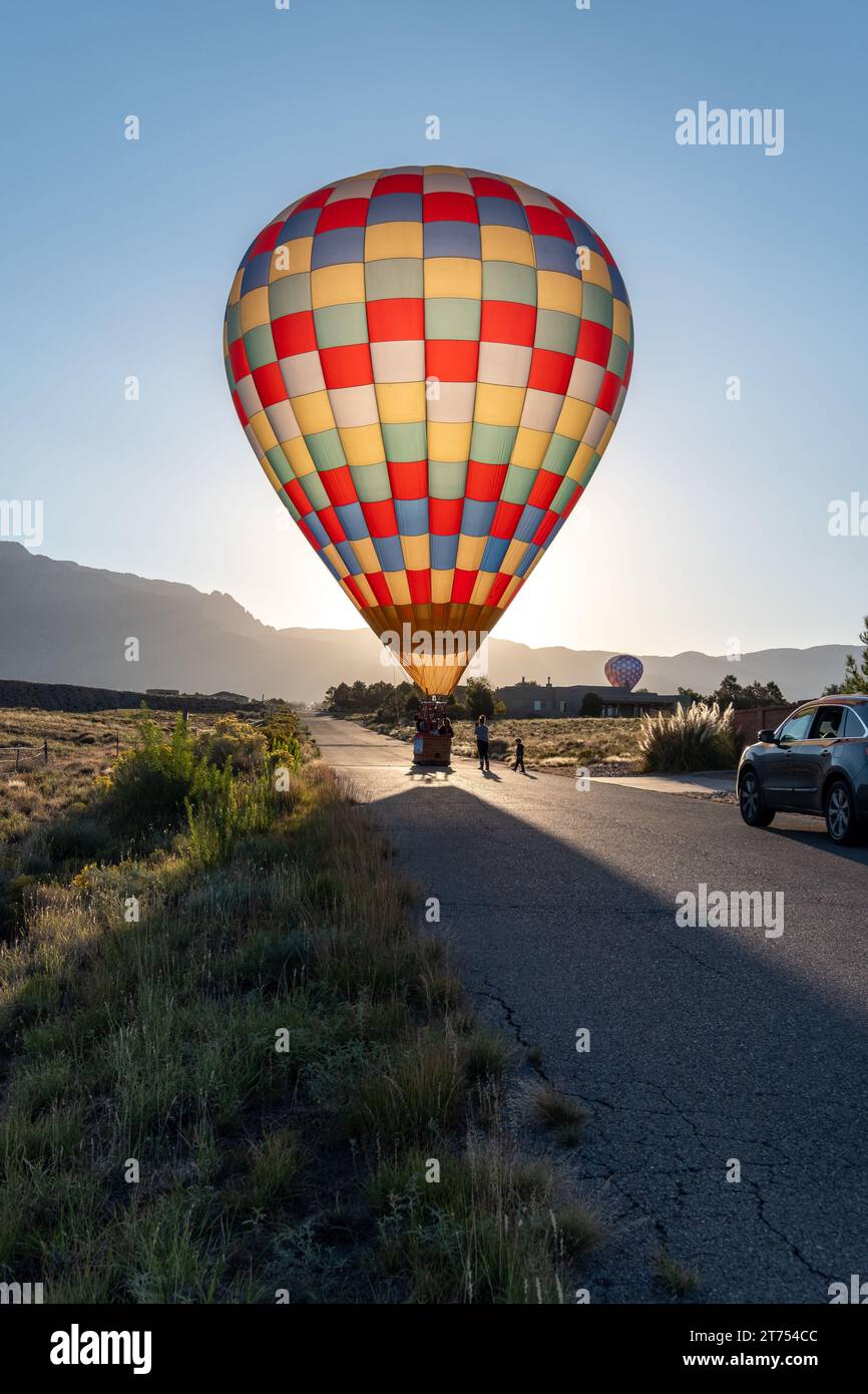A colorful hot air balloon lands on a road in Albuquerque, New Mexico ...