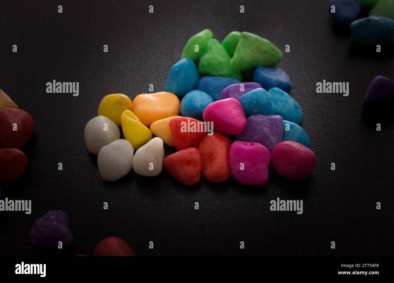 Pile of little colorful pebbles on black background Stock Photo - Alamy