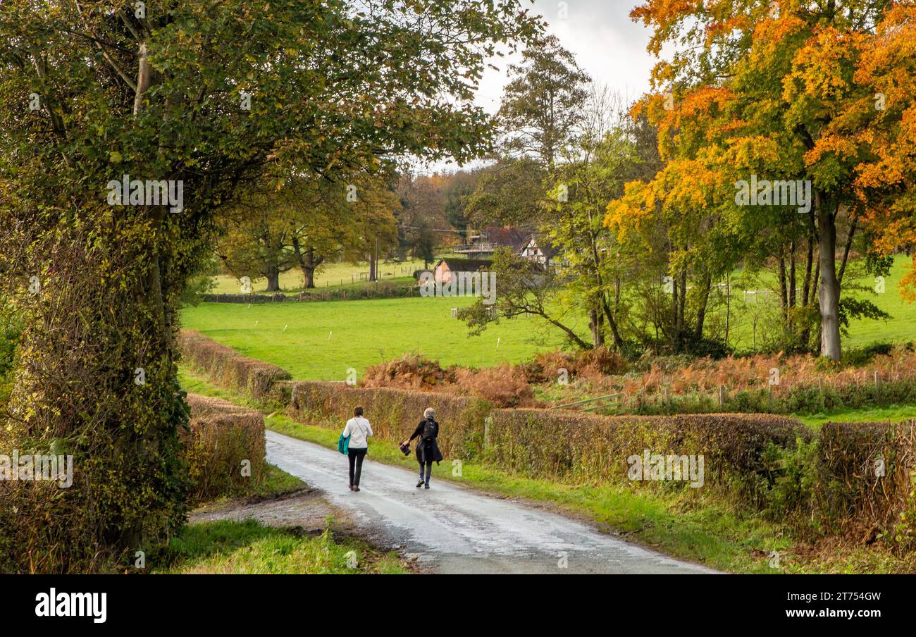 Women walking along a road section of Offas Dyke path forming part of ...