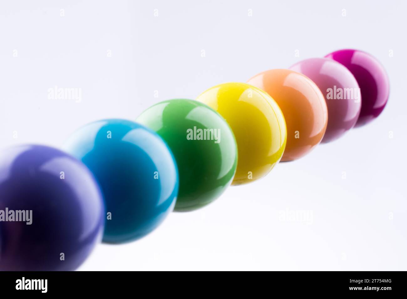 Little color balls in line on a white background Stock Photo - Alamy