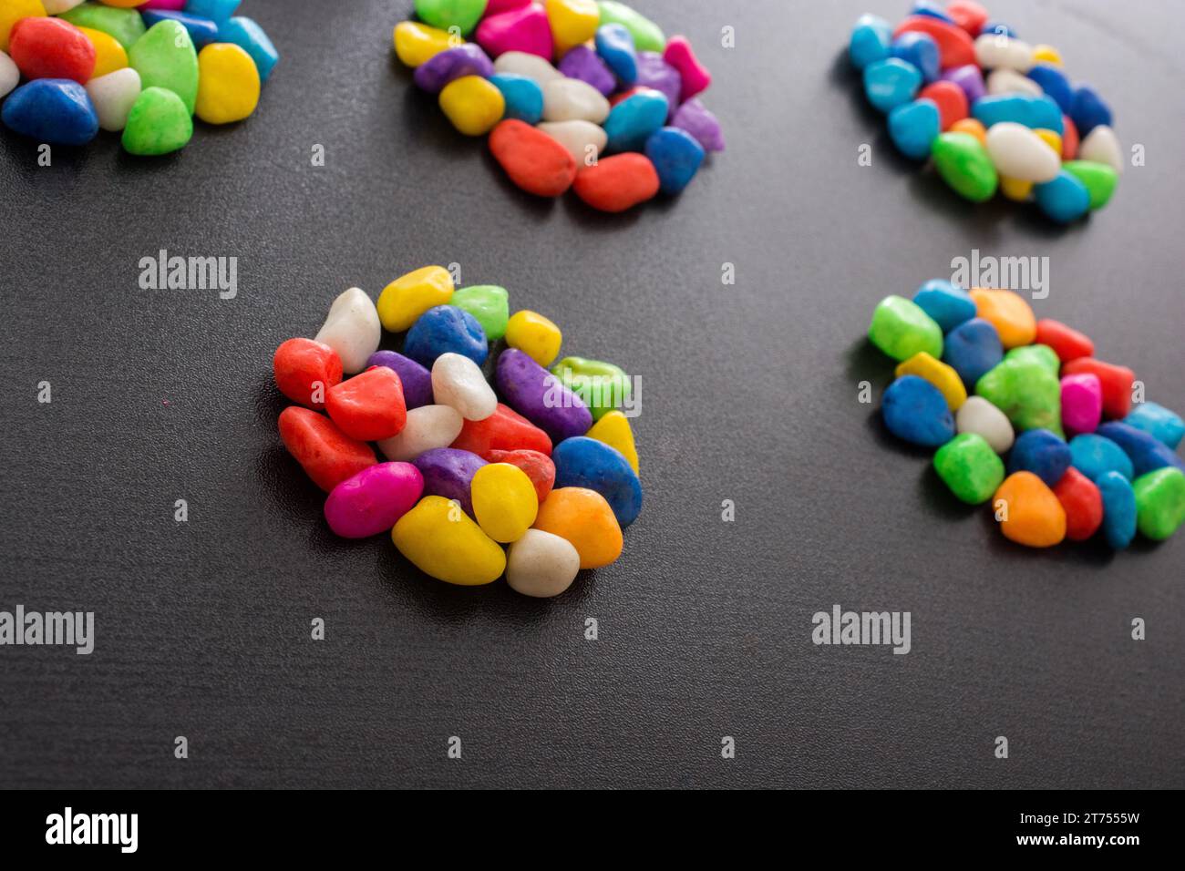 Pile of little colorful pebbles on black background Stock Photo - Alamy
