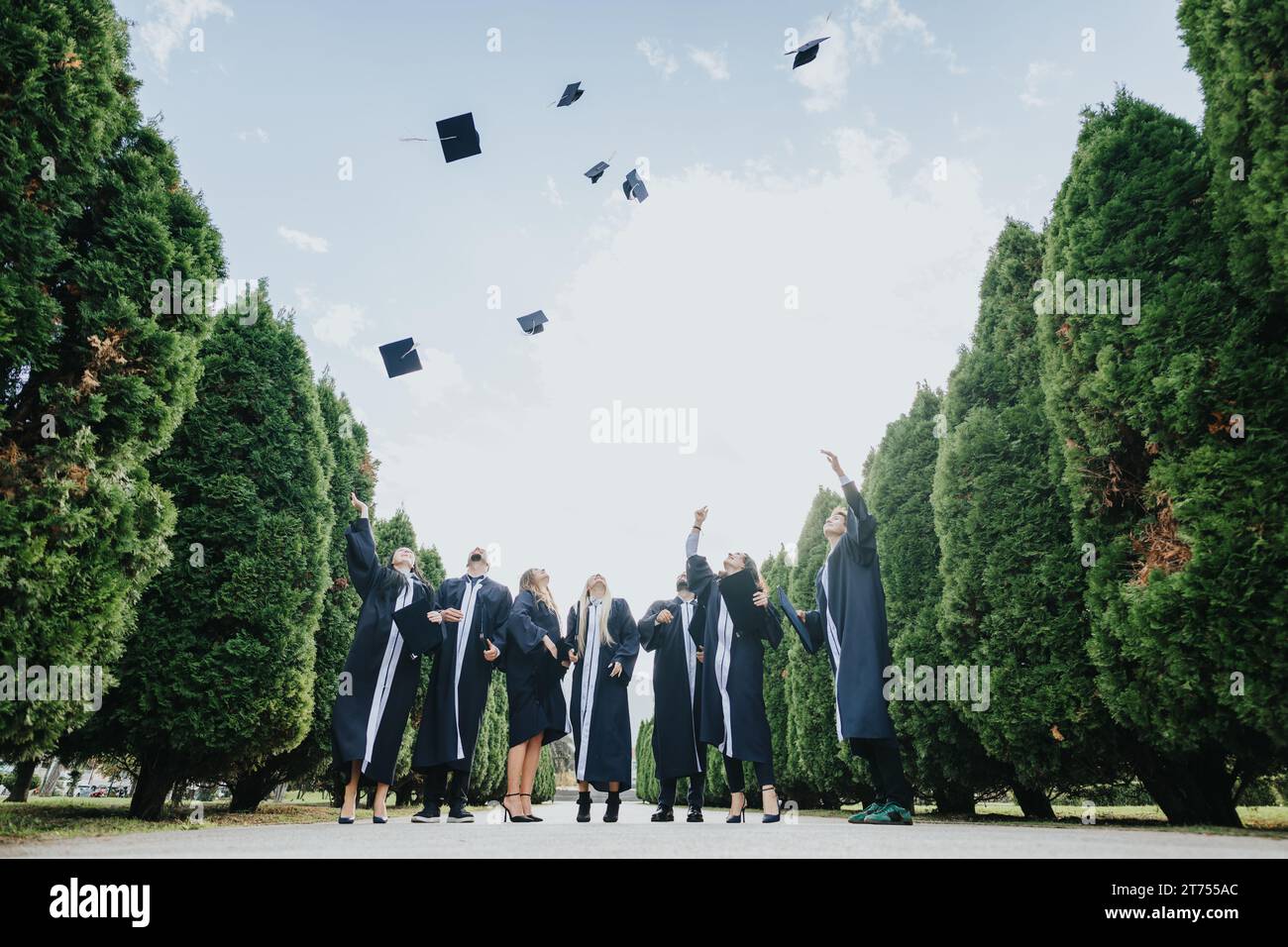 Graduates in caps and gowns celebrate achievements, throwing caps and ... Graduates in caps and gowns celebrate achievements, throwing caps and ...