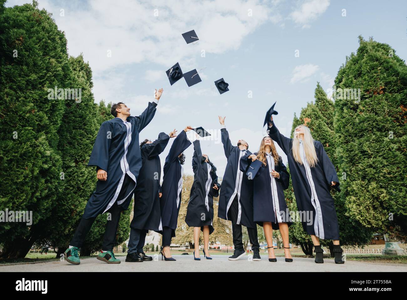 University students throwing their caps in the air, creating beautiful ...