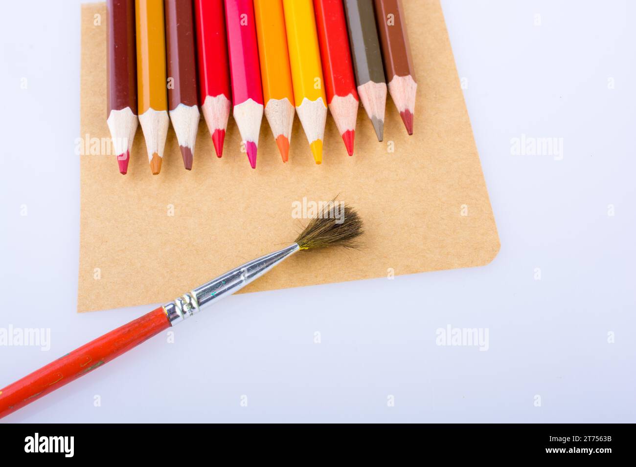 Color pencils and a brush placed on brown sheet of paper Stock Photo ...