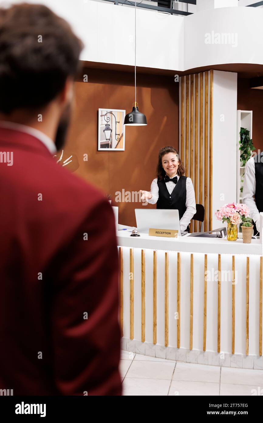 Employee welcoming businessman in lobby, providing luxury services for ...