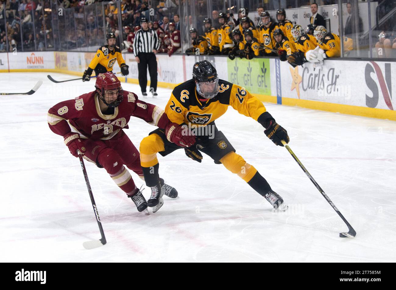 Noah Laba of Colorado College(26 in white)battles for the puck with a ...