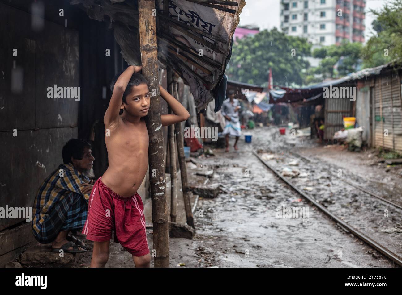 Boy under a canopy of an informal dwelling during a monsoon shower ... Boy under a canopy of an informal dwelling during a monsoon shower ...