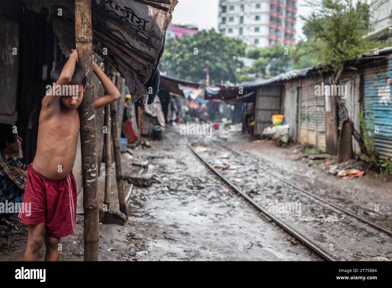 Boy under a canopy of an informal dwelling during a monsoon shower ... Boy under a canopy of an informal dwelling during a monsoon shower ...