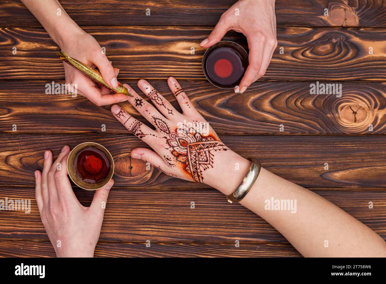 Artist making mehndi womans hand drinking tea Stock Photo - Alamy