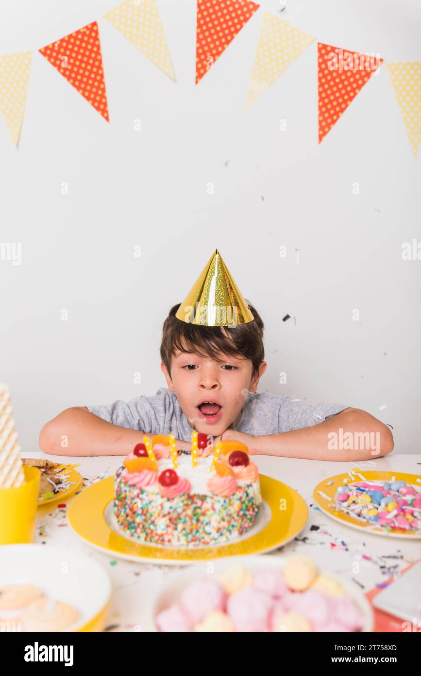Birthday boy blowing out candles cake Stock Photo - Alamy
