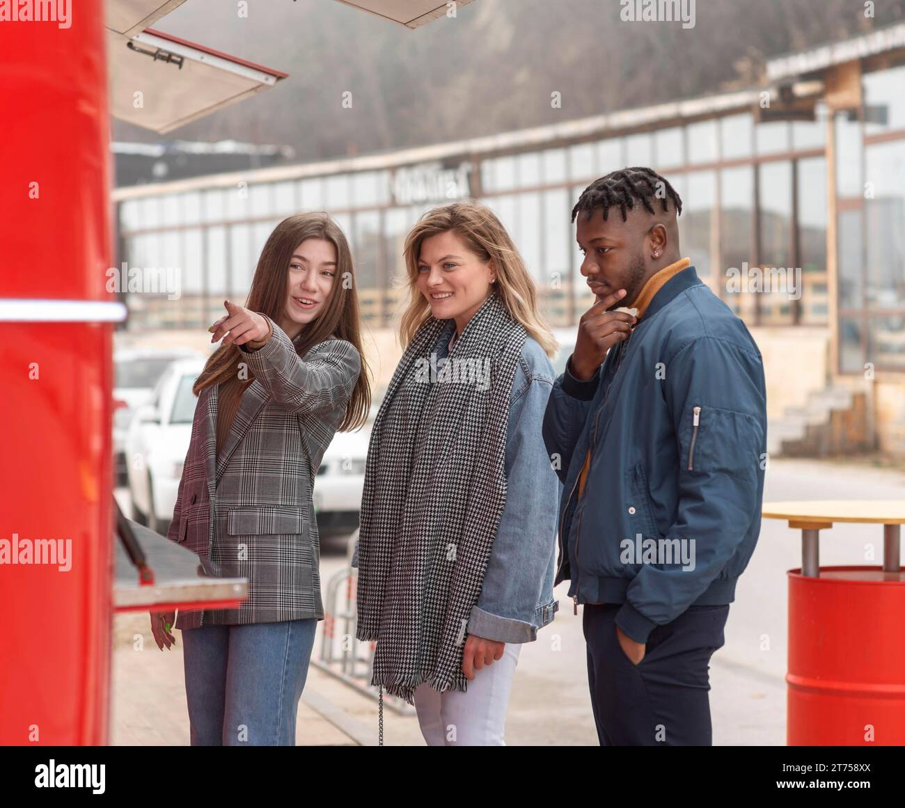 Best friends getting something from food truck Stock Photo - Alamy