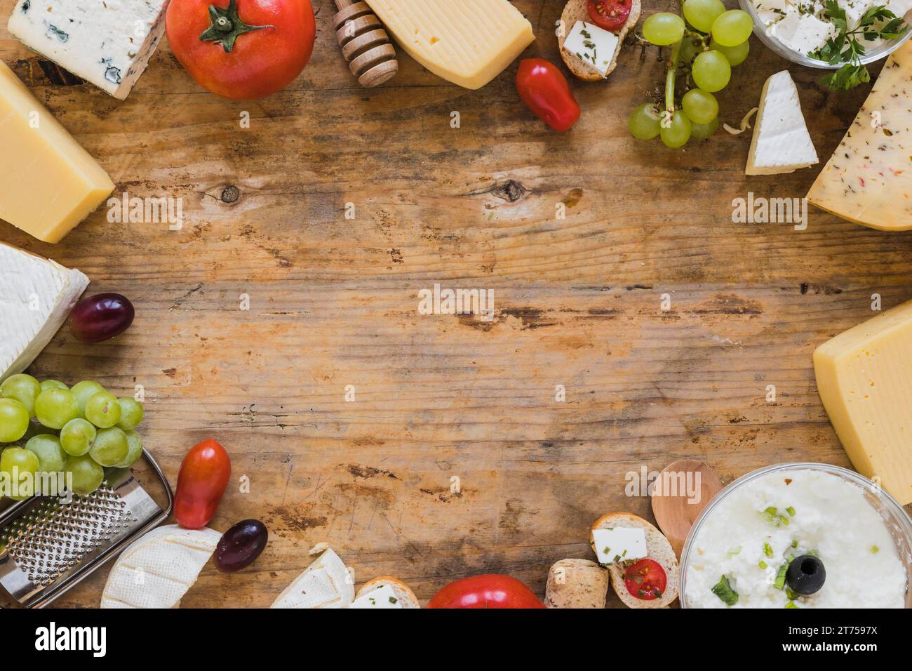 Cheese platter with tomatoes grapes mini sandwiches wooden desk with ...