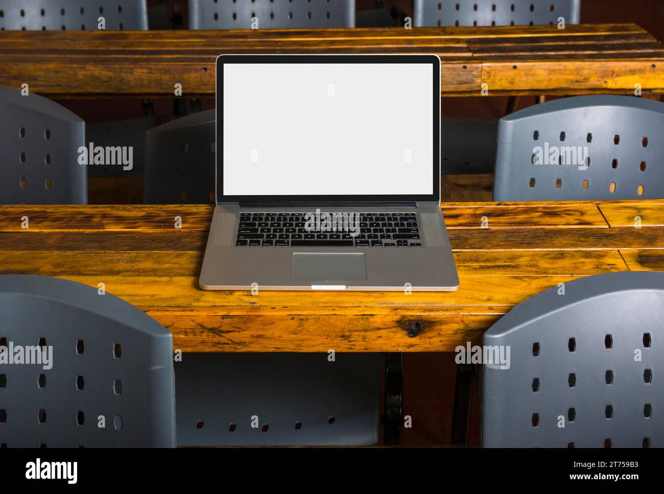 Close up laptop with white screen display wooden desk with chairs near ...