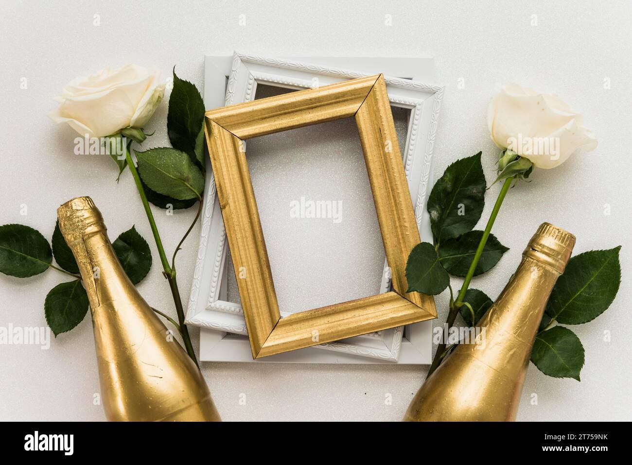 Elevated view picture frames with two roses champagne bottle white ...