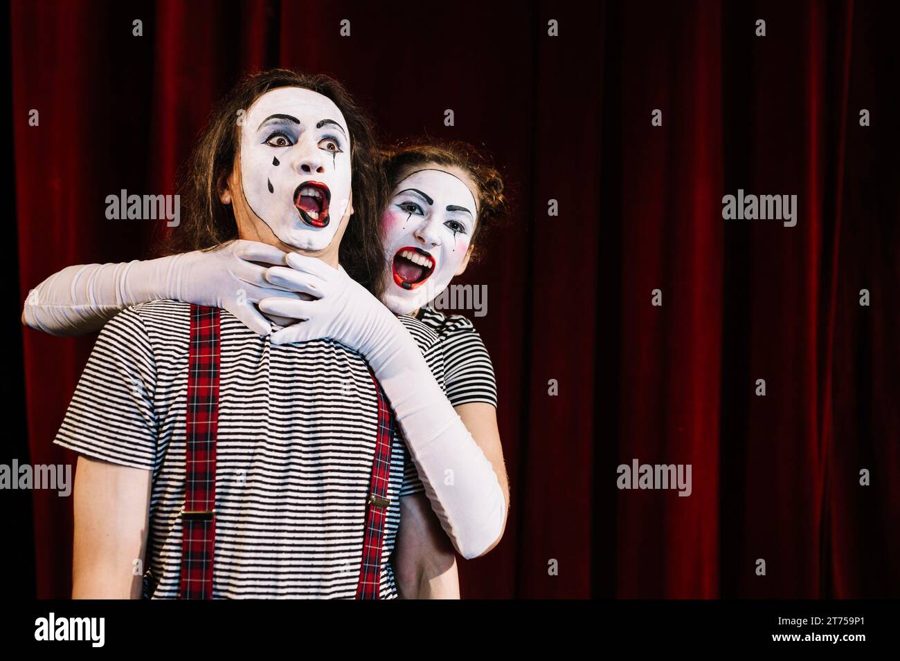Female mime artist grabbing male mime s neck Stock Photo - Alamy