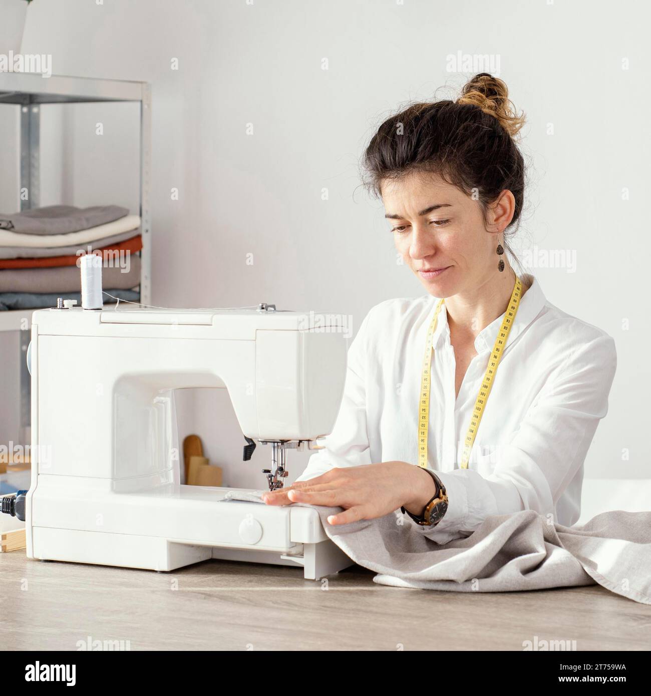Front view female tailor working with sewing machine Stock Photo - Alamy