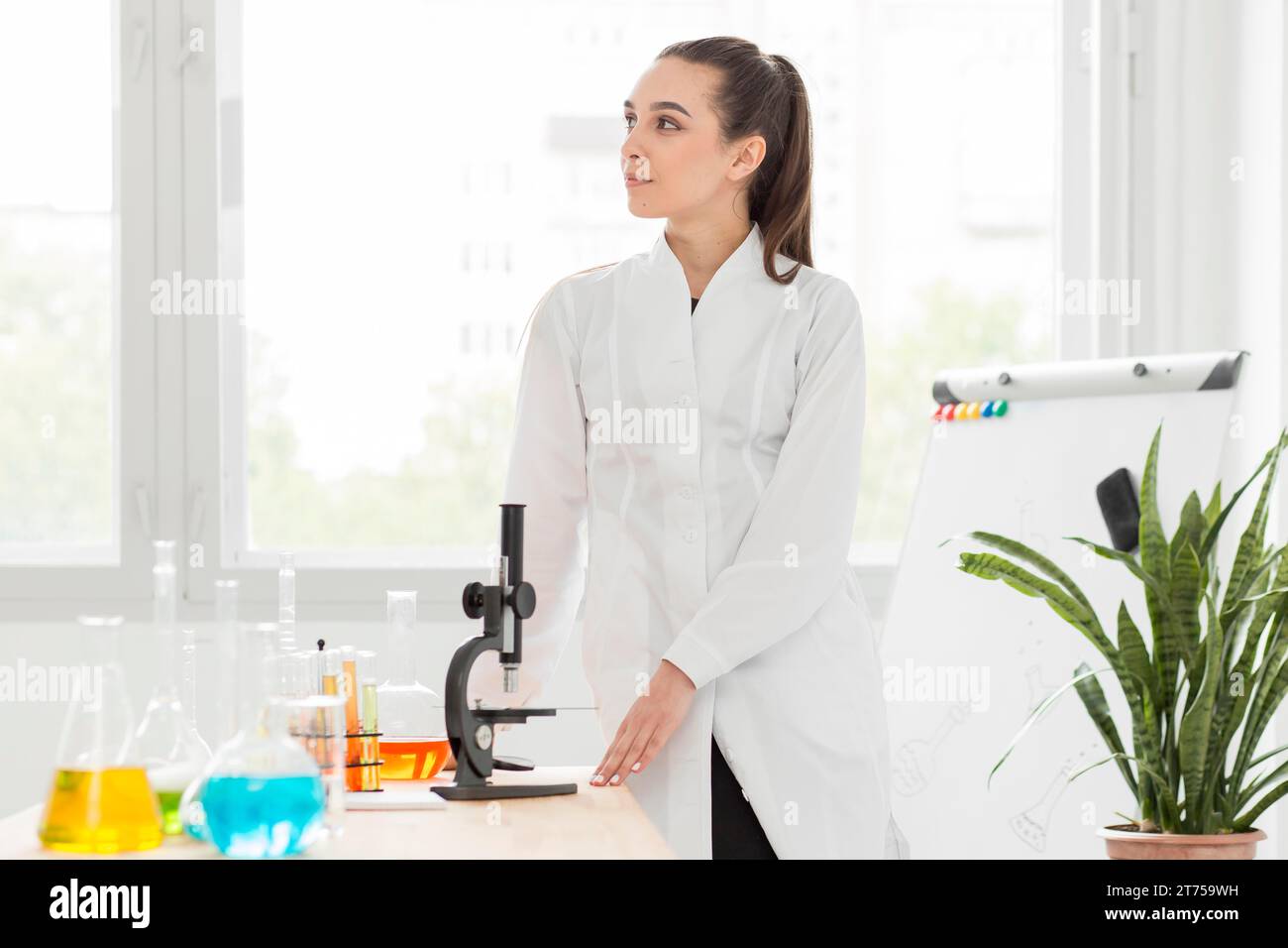 Front view female scientist posing microscope Stock Photo - Alamy