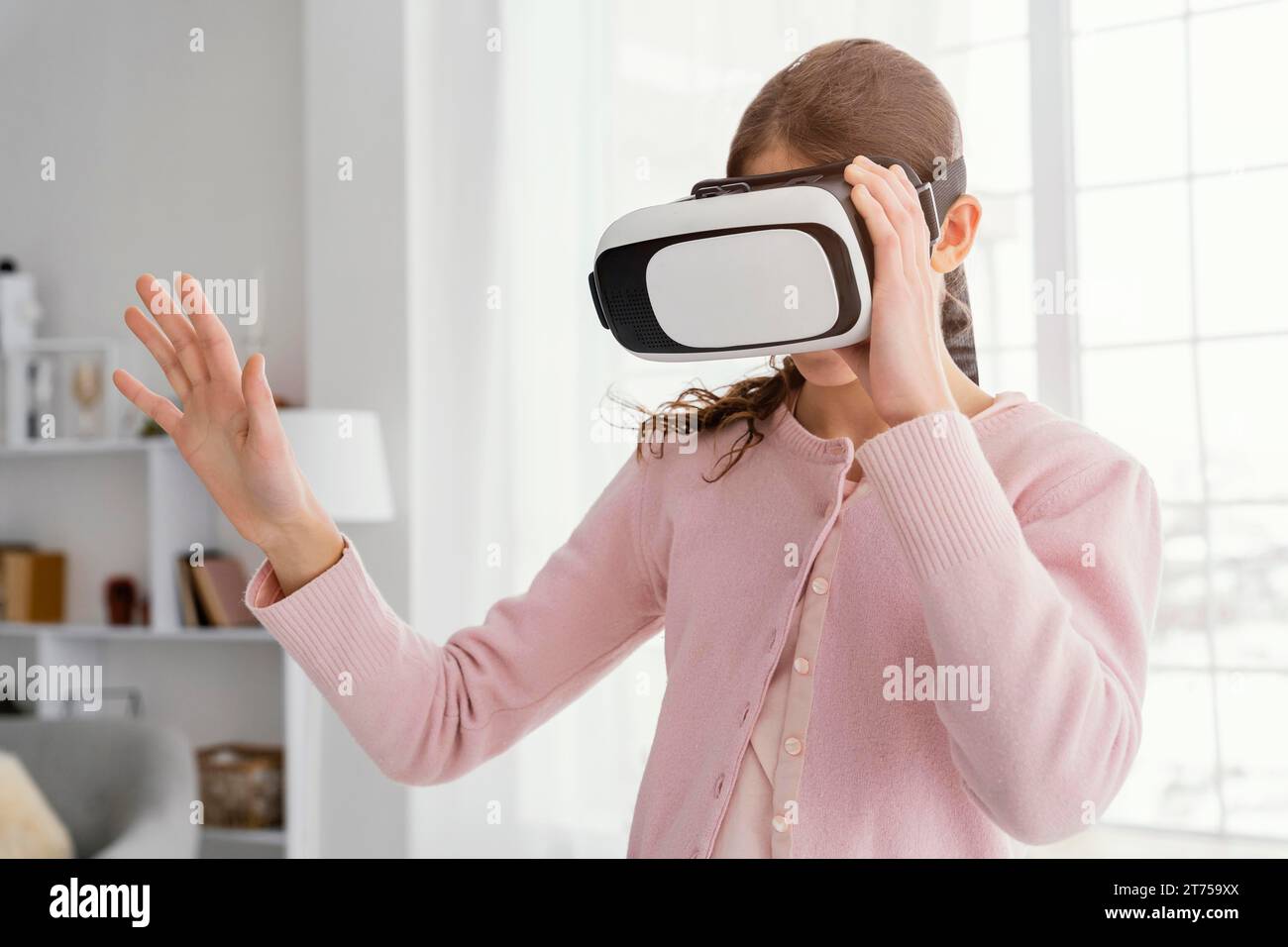 Front view little girl playing with virtual reality headset Stock Photo ...