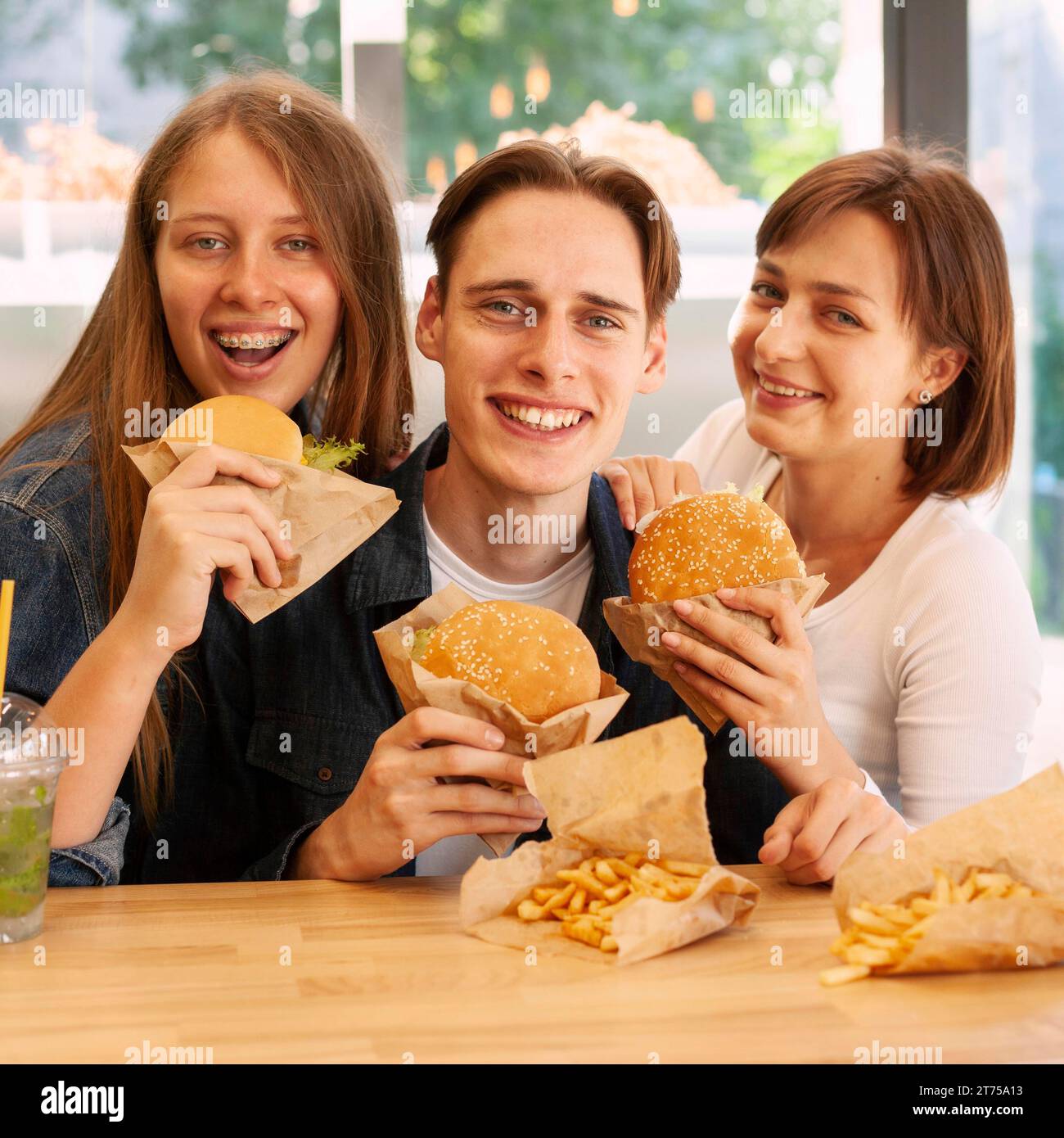 Group friends fast food restaurant eating hamburgers Stock Photo - Alamy