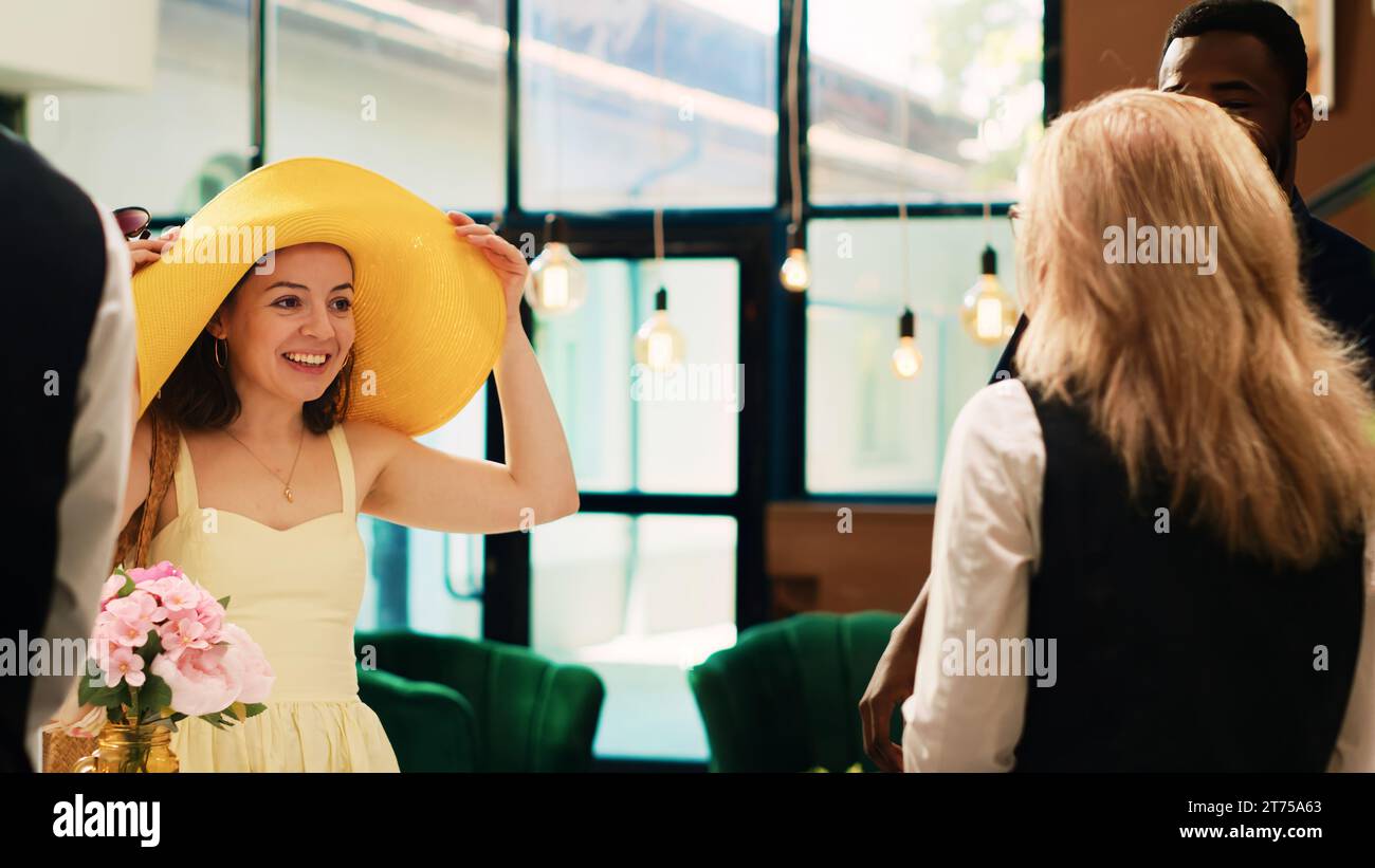Receptionist greeting guests at hotel, reviewing booking reservation ...