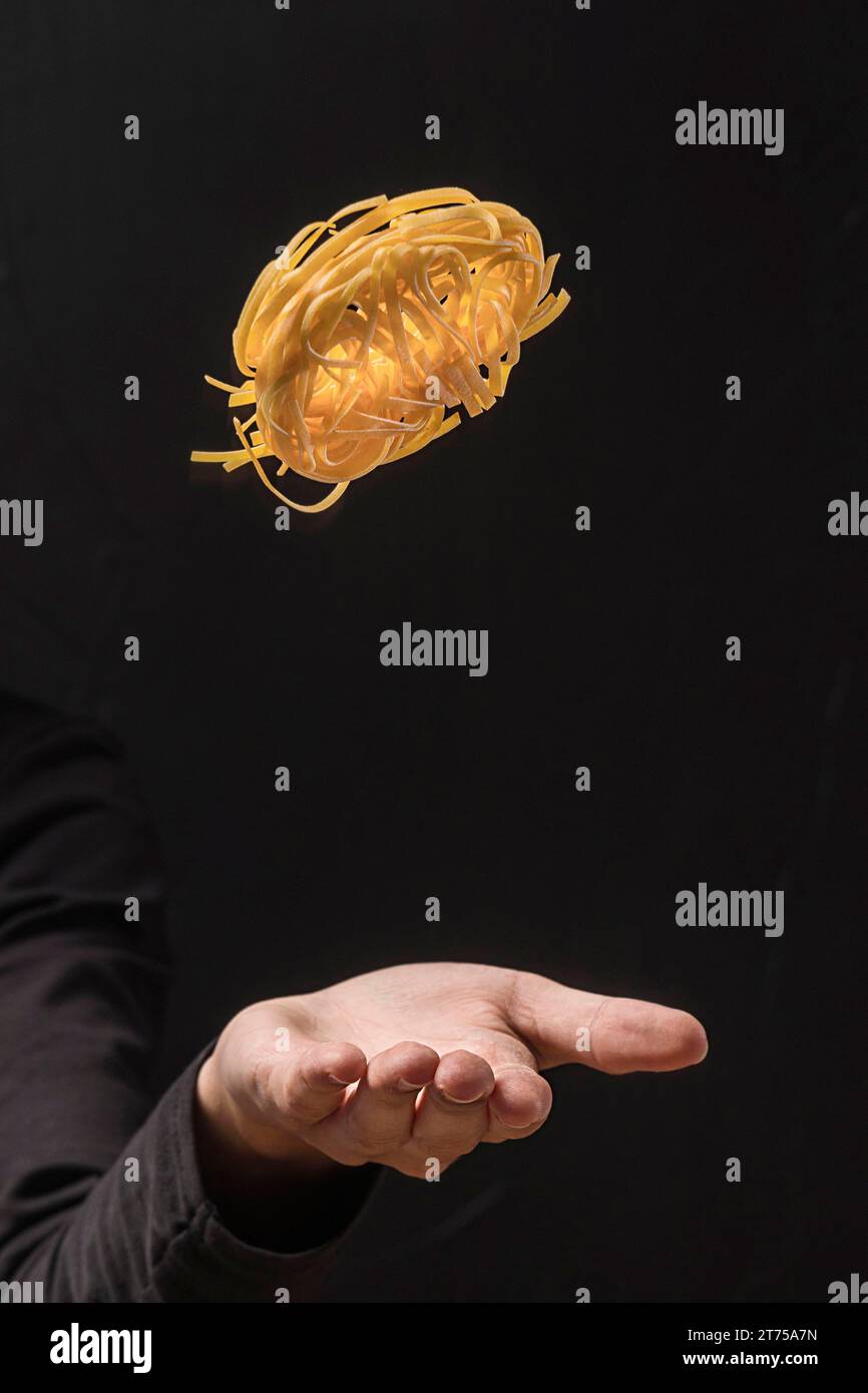 Hand throwing pasta up air Stock Photo - Alamy