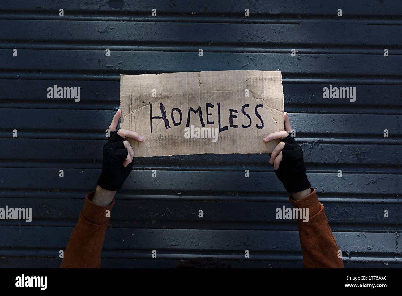 Homeless sign held by beggar hands Stock Photo - Alamy