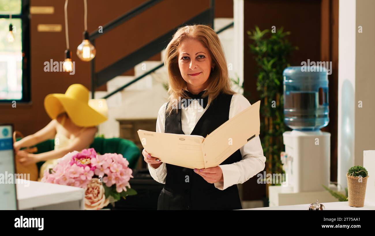 Hotel concierge reviewing bookings or reservations, working at ...
