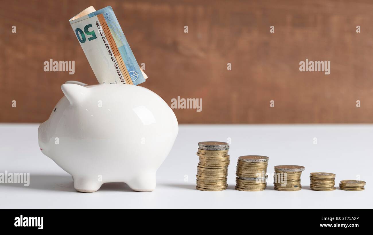 Side view piggy bank with coins banknotes Stock Photo - Alamy