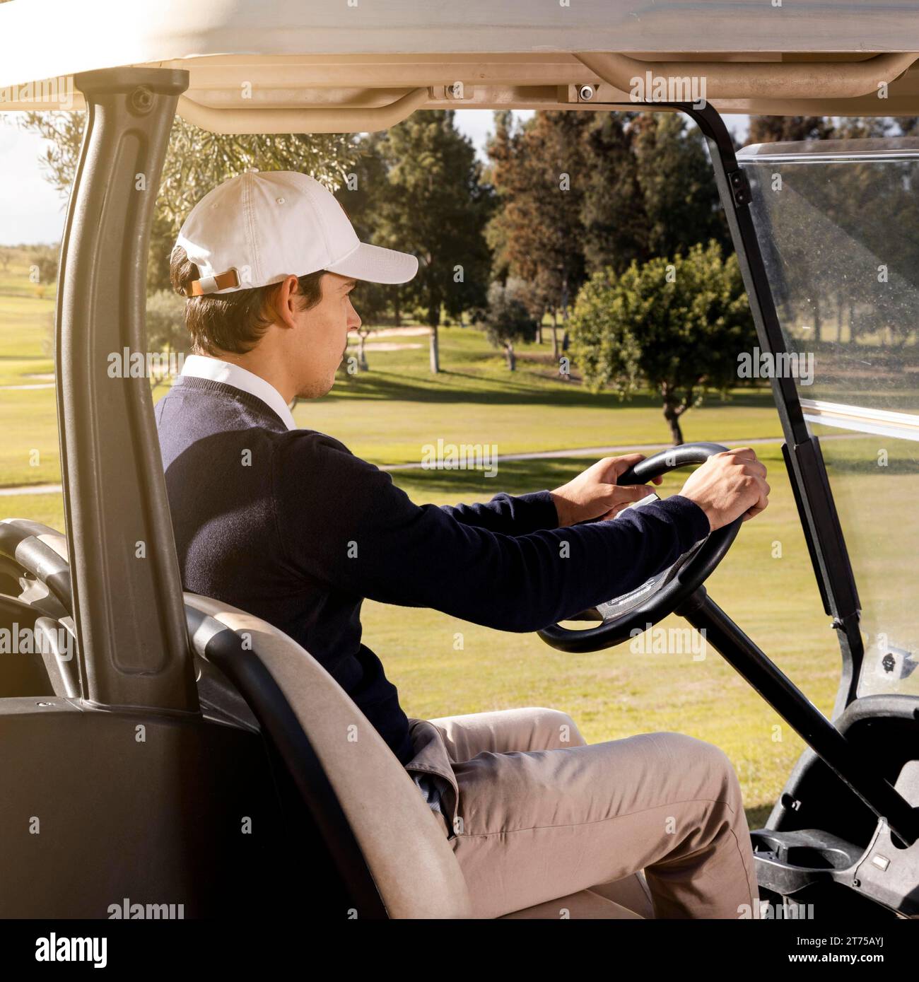 Side view man driving golf cart field Stock Photo - Alamy