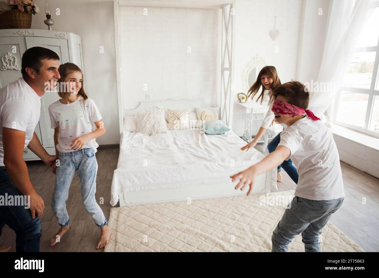 Smiling family playing blind man s buff bedroom Stock Photo - Alamy