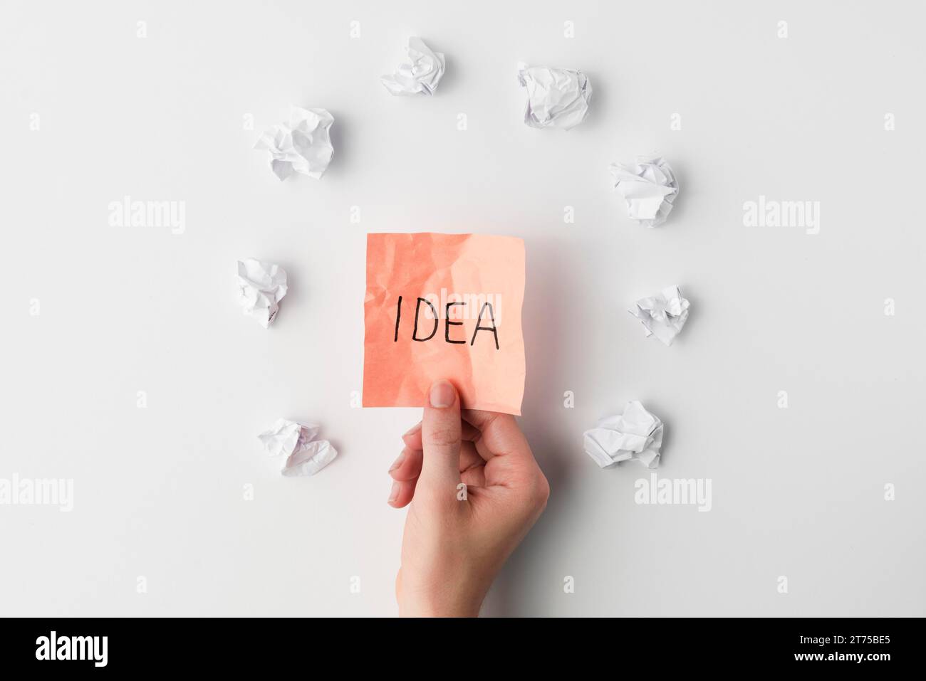 Top view human hand holding sticky note with idea text surrounded by ...
