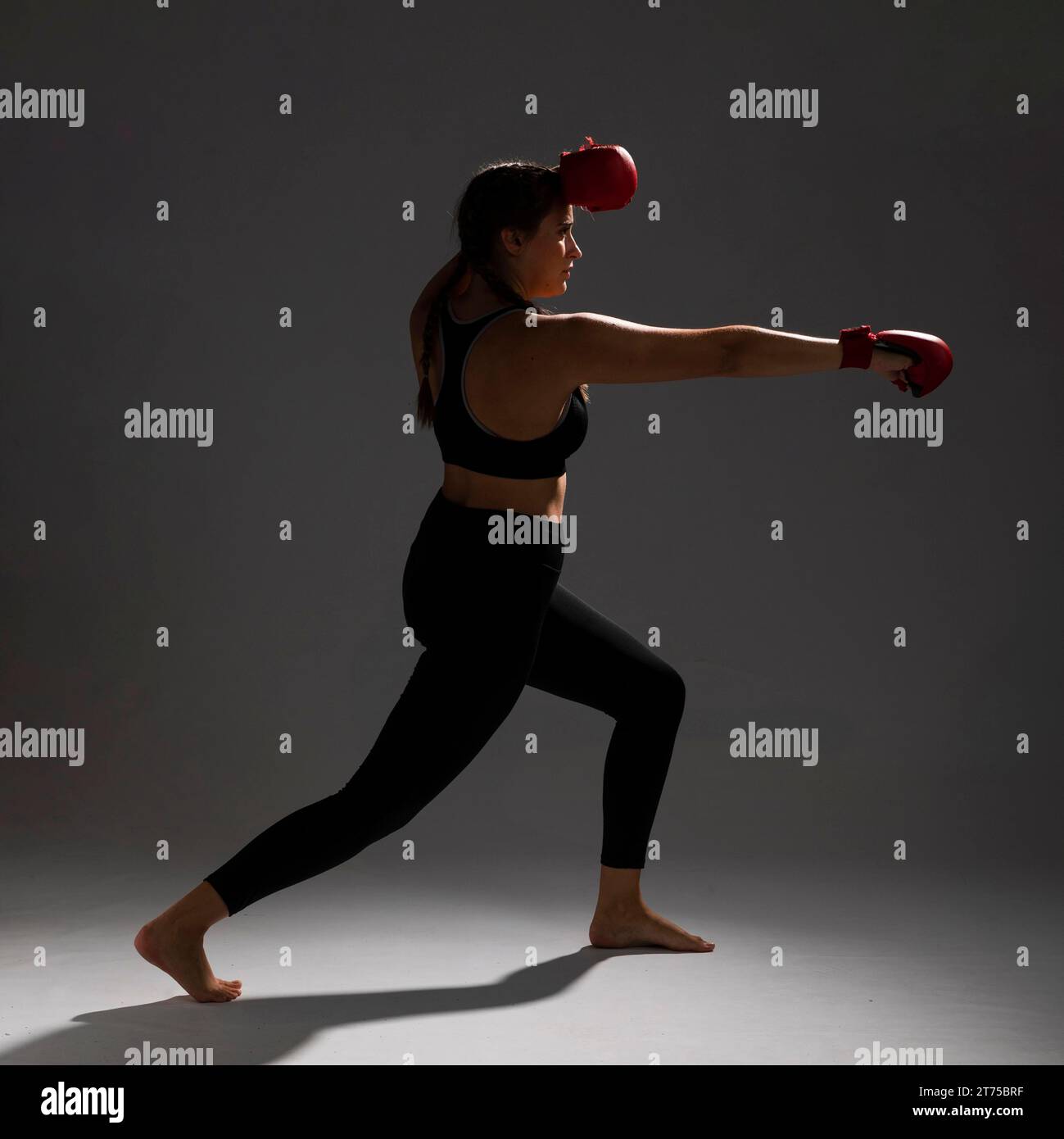 Woman sideways punching with box gloves Stock Photo - Alamy