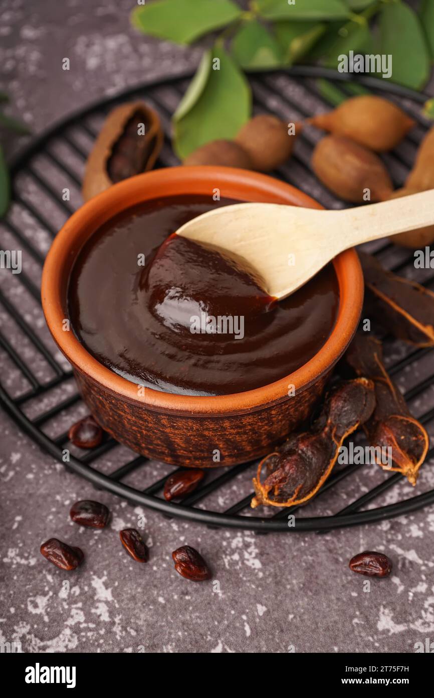 Bowl of tasty tamarind jam and fruits on grey background Stock Photo ...