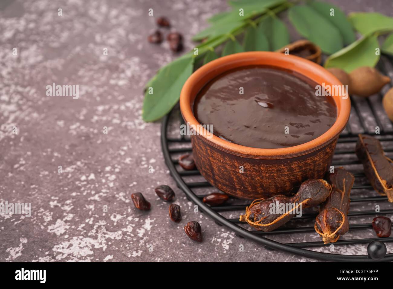 Bowl of tasty tamarind jam and fruits on grey background Stock Photo ...