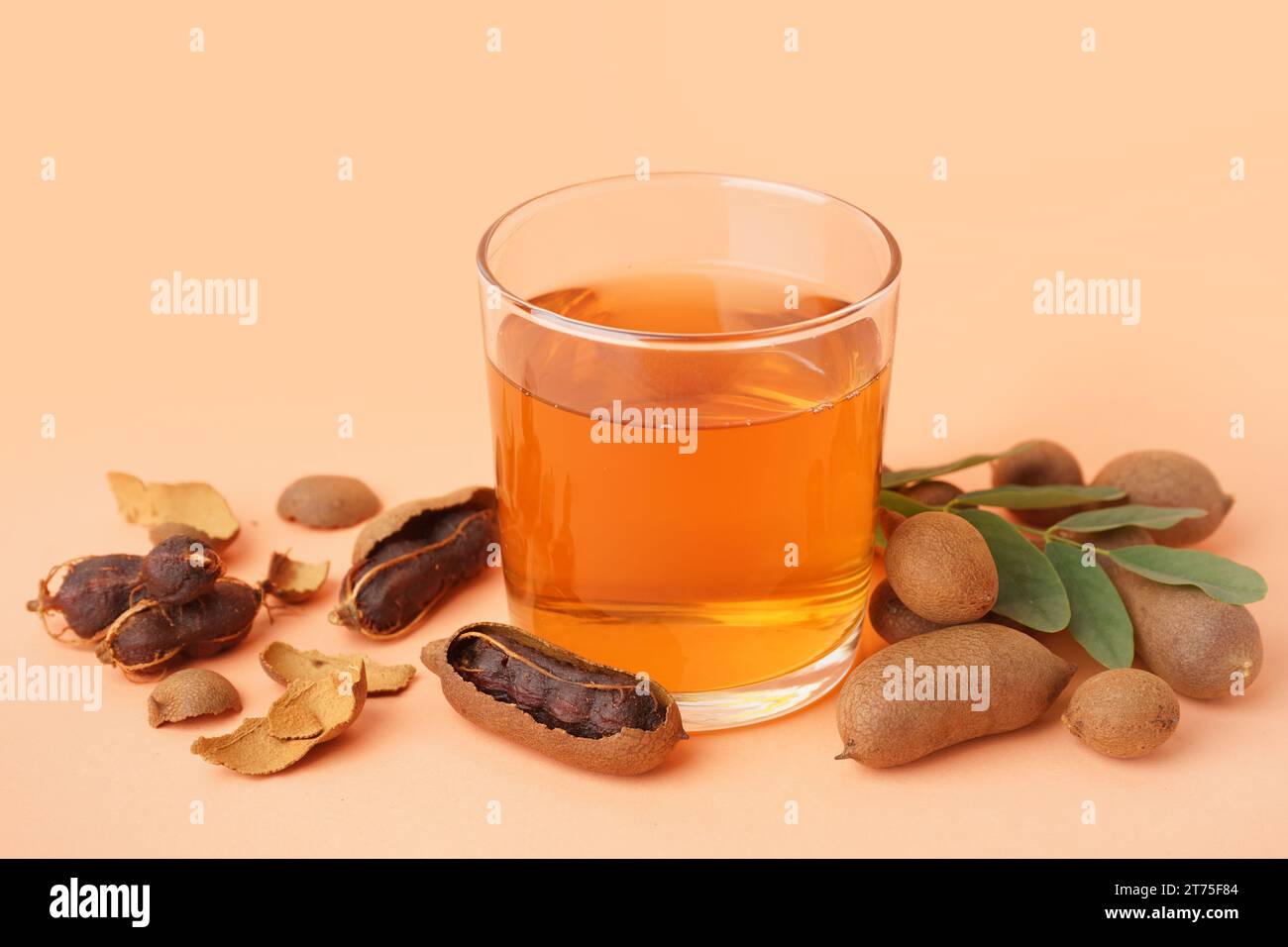 Glass of tasty tamarind drink and fruits on orange background Stock ...