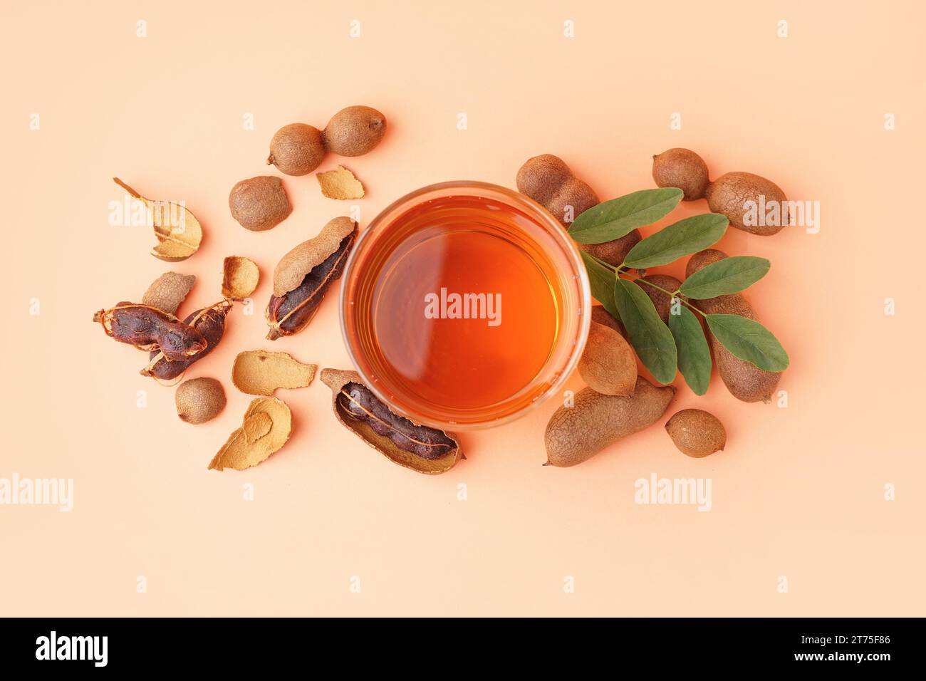Glass of tasty tamarind drink and fruits on orange background Stock ...