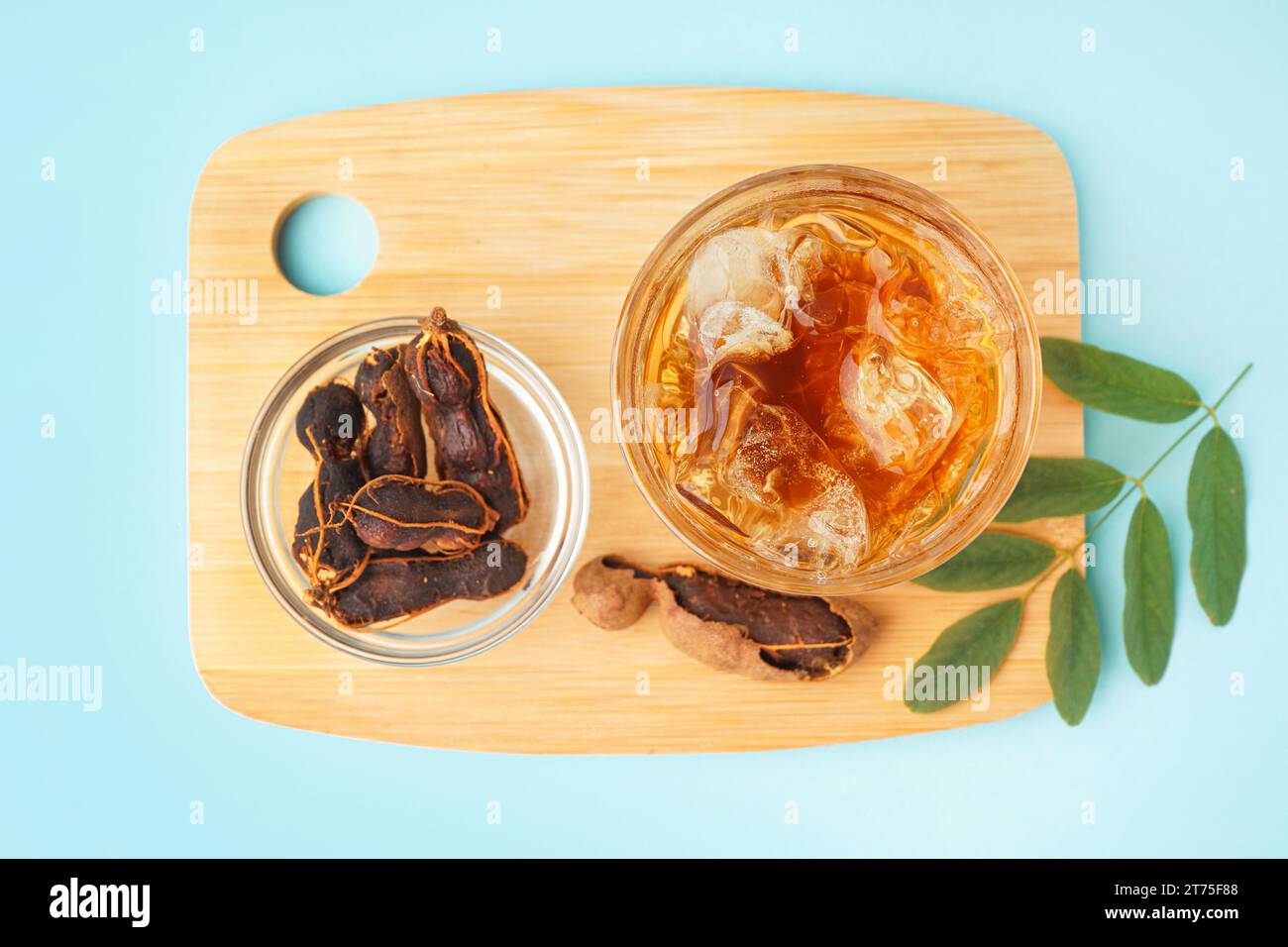 Glass of tasty tamarind drink and fruits on blue background Stock Photo ...