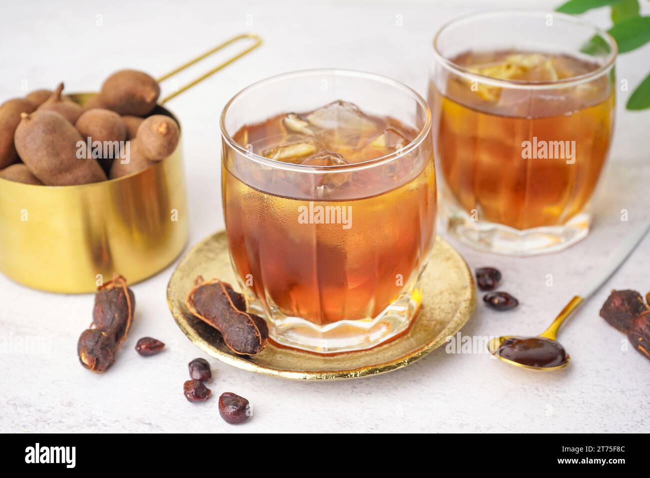 Glasses of tasty tamarind drink and fruits on white background Stock ...