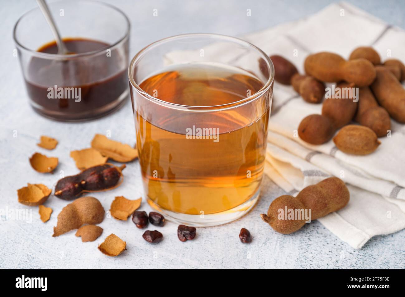 Glass of tasty tamarind drink and fruits on white background Stock ...