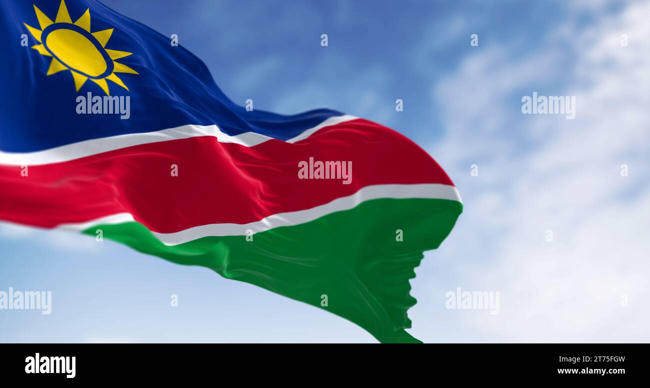 Namibia national flag waving on a clear day. Blue stripes, yellow sun ...