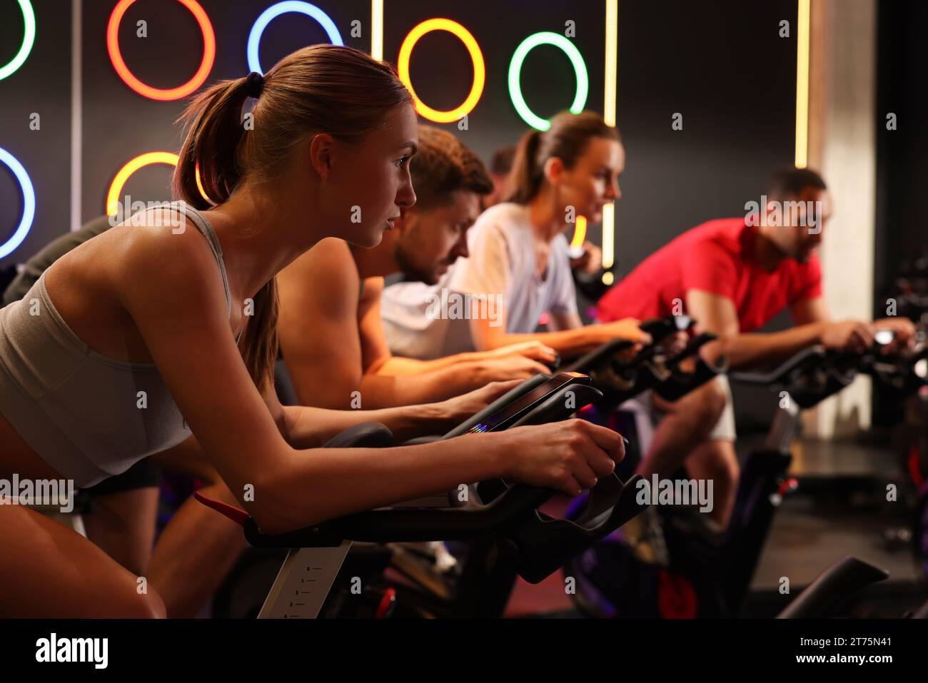 Group of people training on exercise bikes in fitness club Stock Photo ...