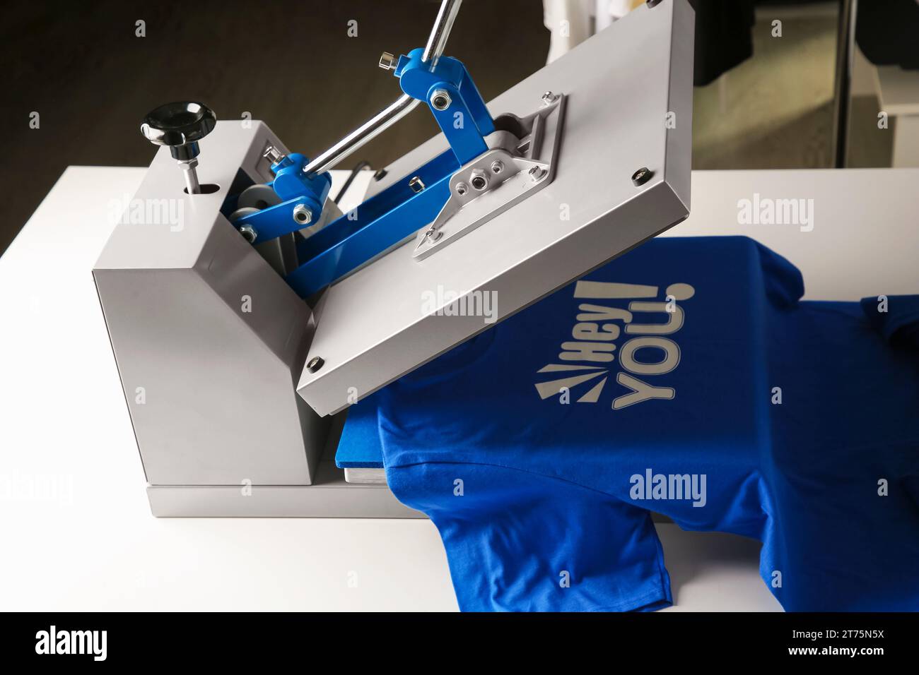 Printing logo. Heat press with blue t-shirt on white table Stock Photo ...